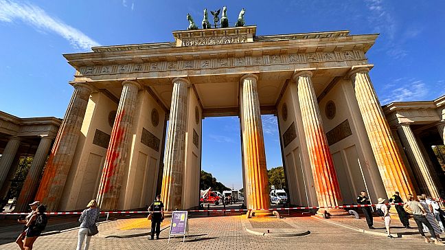 Activists spray the Brandenburg Gate orange as global protests call for ...