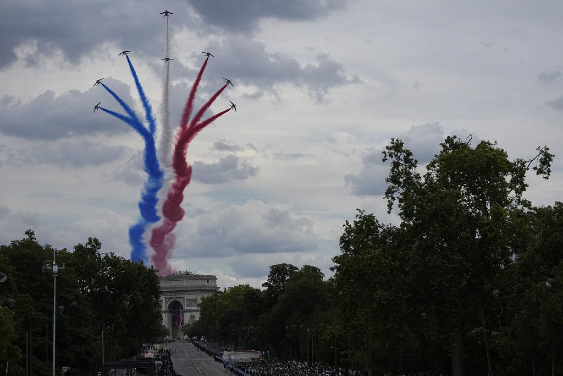 The Olympic torch lights up France's Bastille Day military parade ...