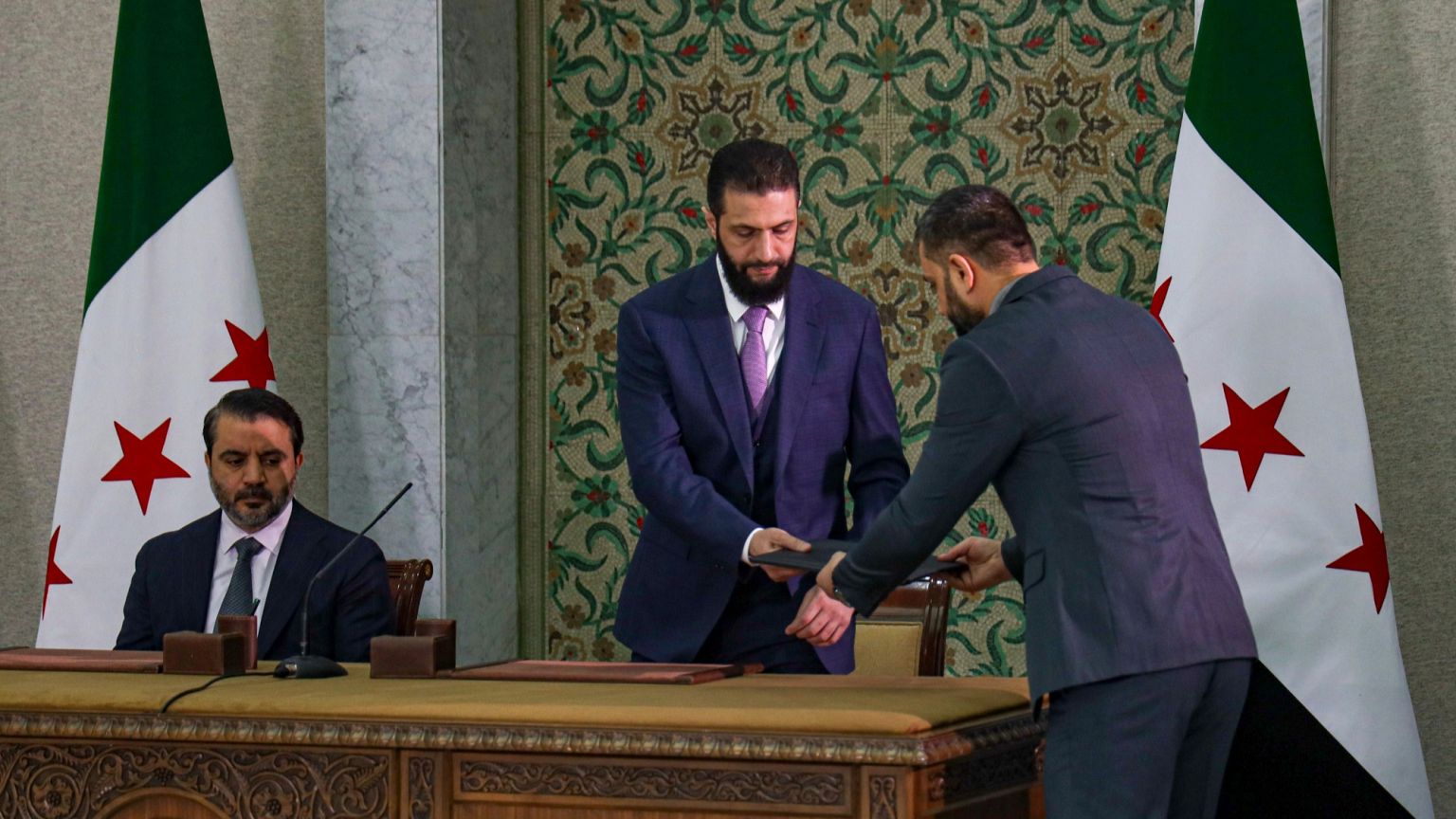 Syria's interim president signs temporary constitution amid ongoing ...